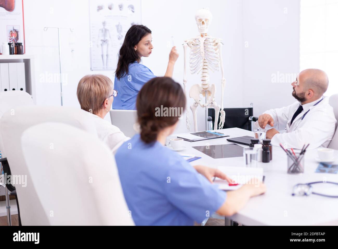 Nurse giving presentation in front of doctors team about human anatomy ...