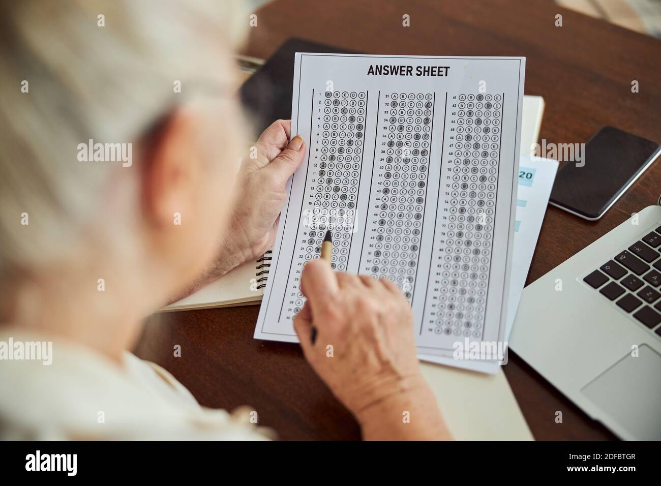 Senior woman checking answers for test at home Stock Photo - Alamy