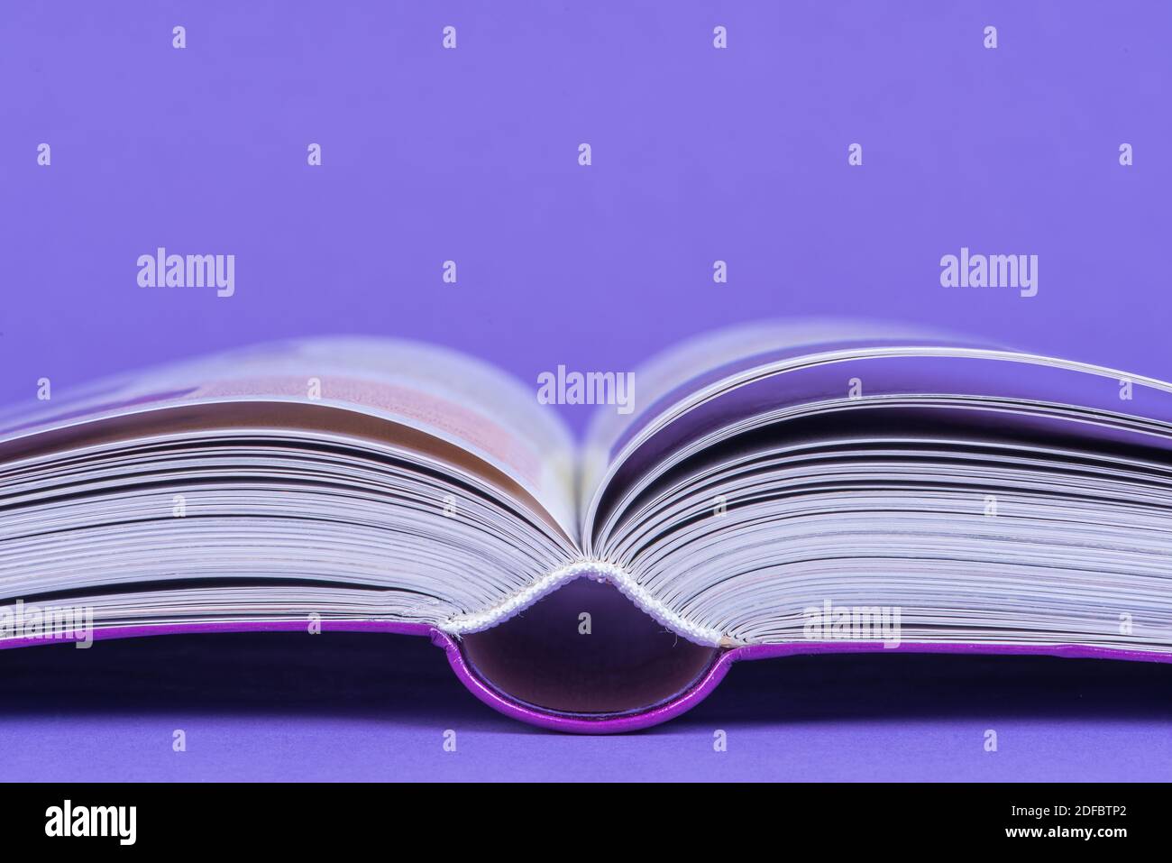 Open book closeup on blank purple background Stock Photo - Alamy