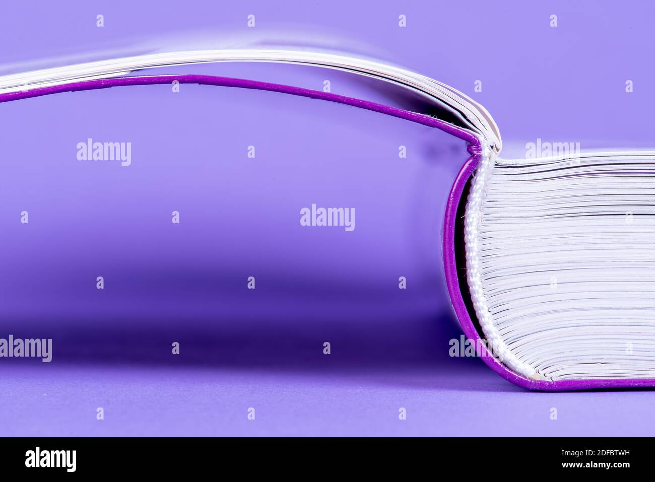 Open book close-up on purple background Stock Photo - Alamy
