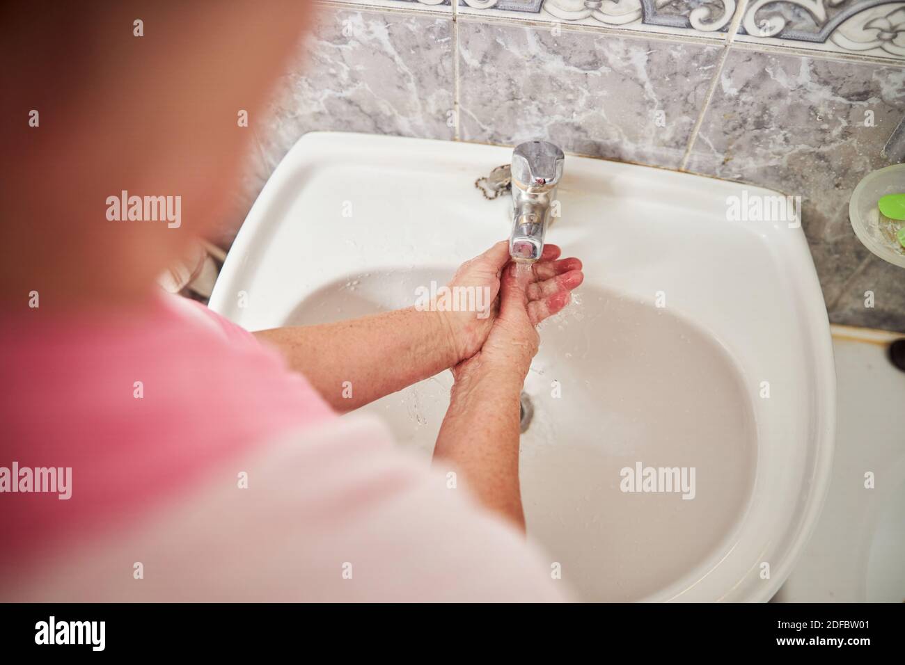 Old woman washing hands in bathroom at home Stock Photo - Alamy