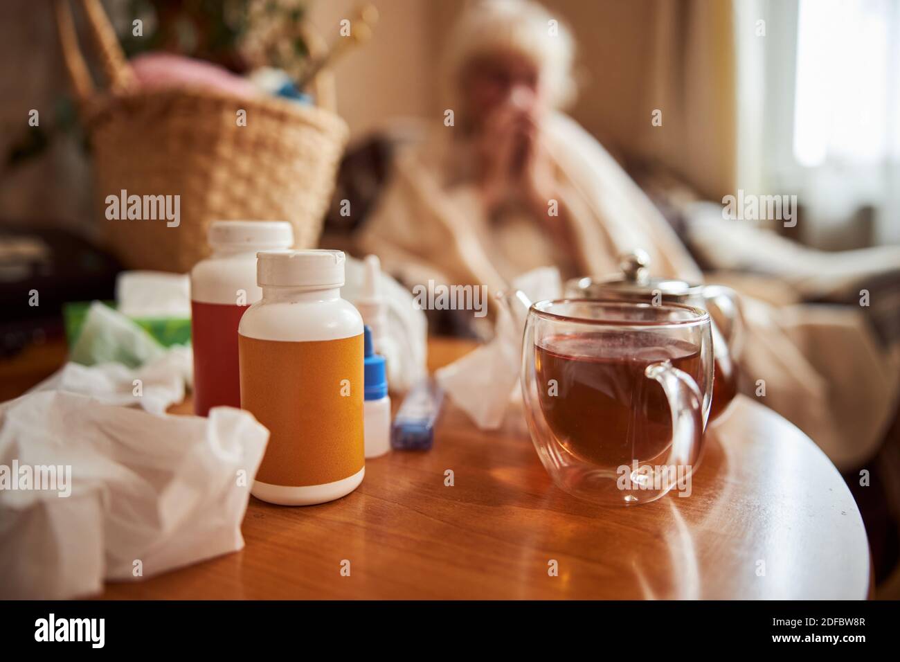 Wooden table with cup of tea and medicaments Stock Photo - Alamy