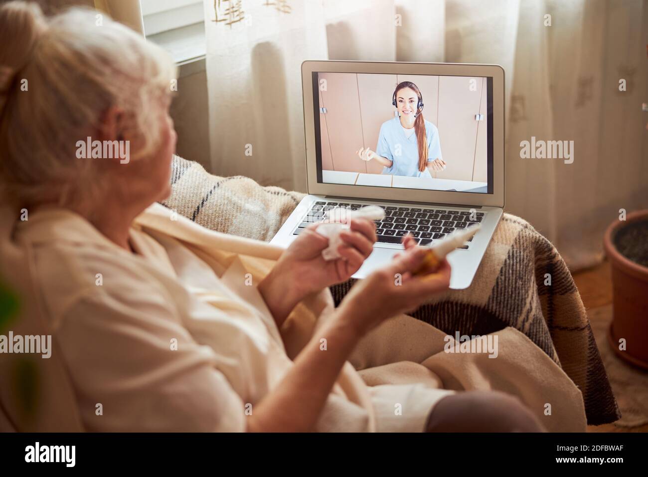 Old woman with flu having online consultation with doctor at home Stock ...