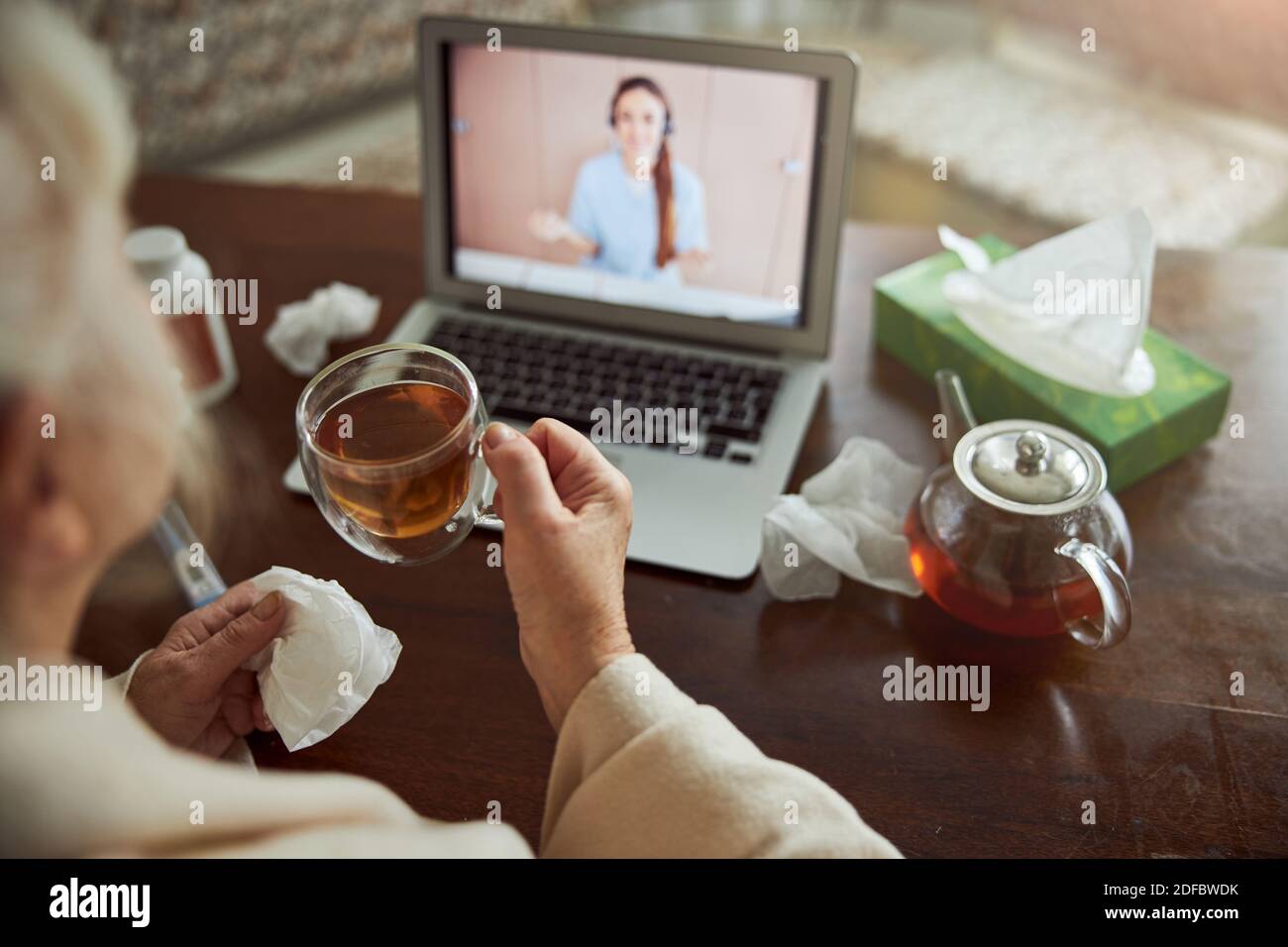 Old lady drinking tea and having online consultation with doctor Stock ...