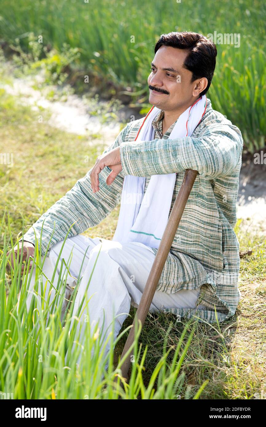 Happy Indian farmer sitting in agricultural field Stock Photo - Alamy