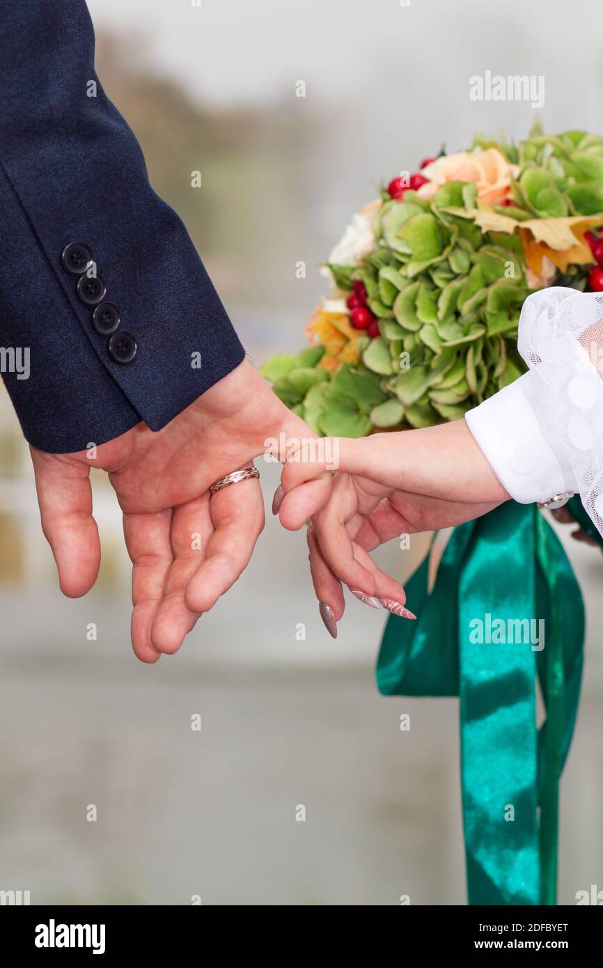 The bride and groom hold hands on the wedding day. Wedding traditions ...