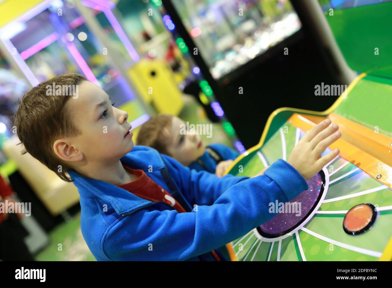 Two brothers playing arcade game in amusement park Stock Photo - Alamy