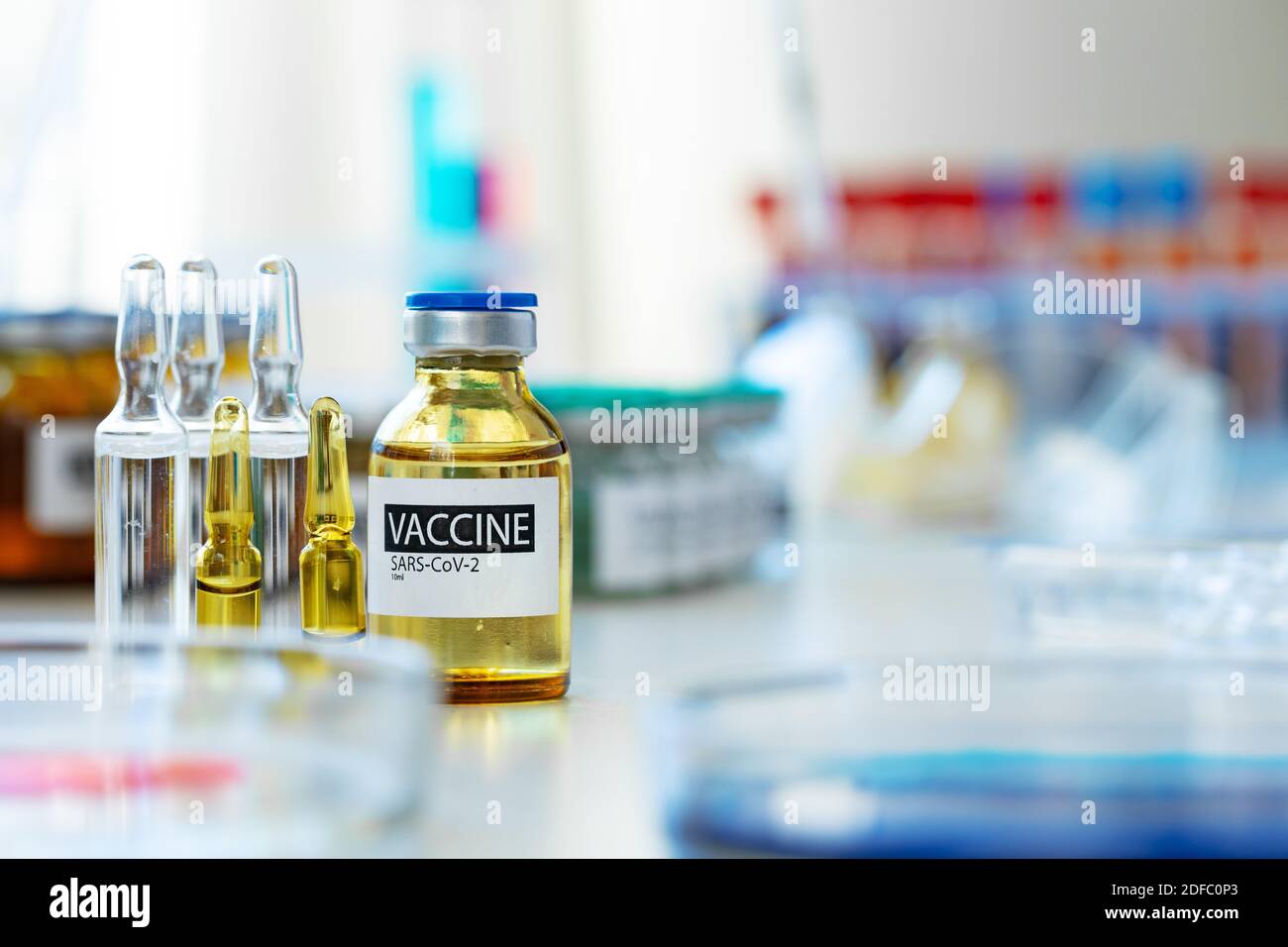 Vaccine in vial for injection on table against background of laboratory ...