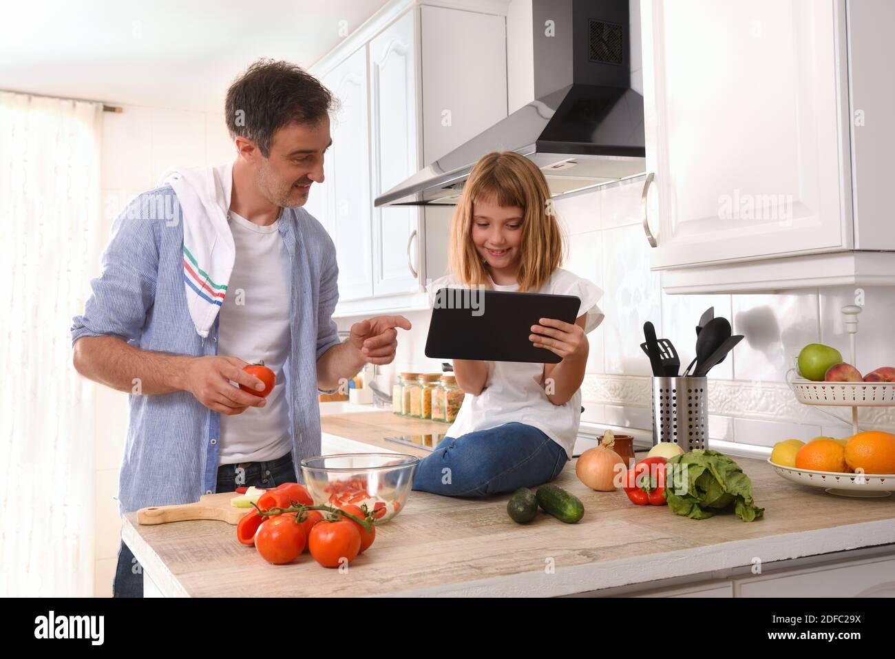 Happy father and daughter preparing vegetables to make a plate of food ...