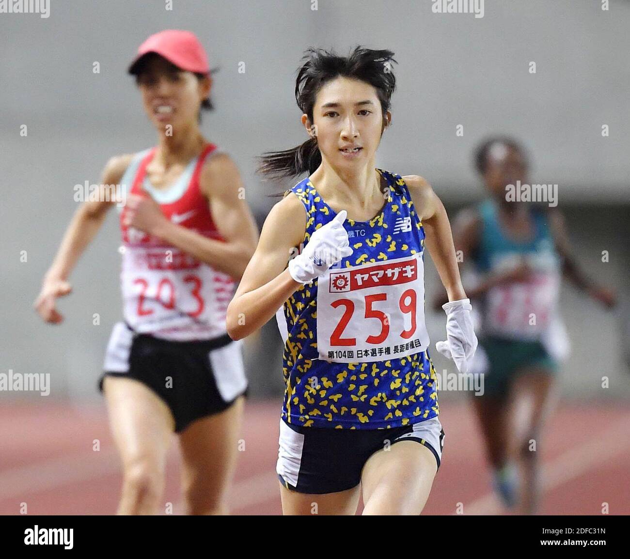 Nozomi Tanaka (front) runs en route to winning the women's 5,000 meters ...