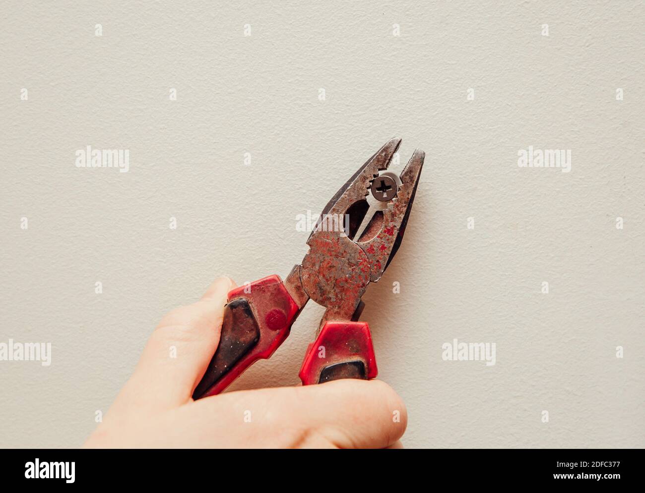 Close up view of person hand removing old plastic dowel, nylon wall ...