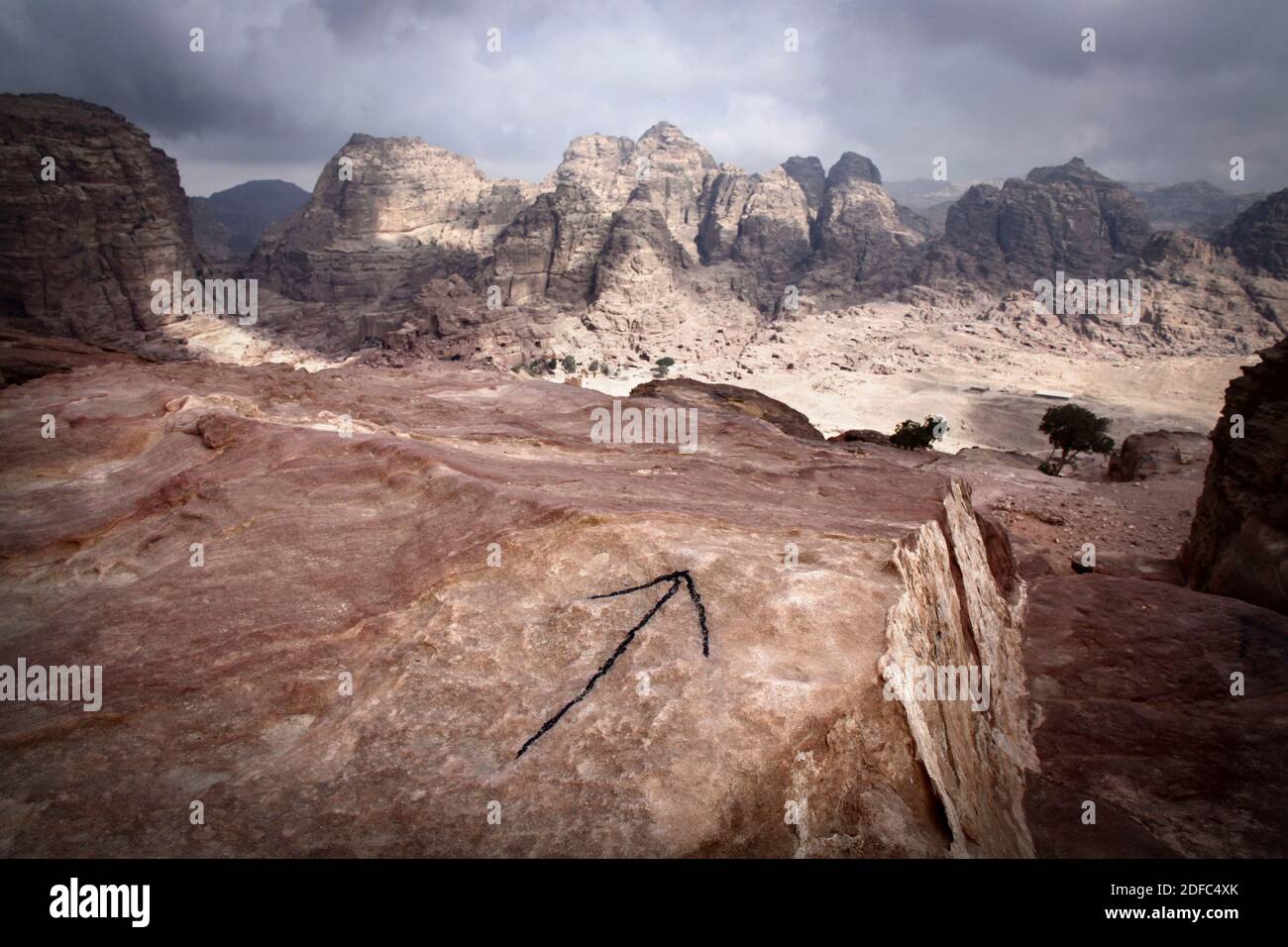 Jordan, a mountain at the site of Petra, arrow painted on rock shows a ...