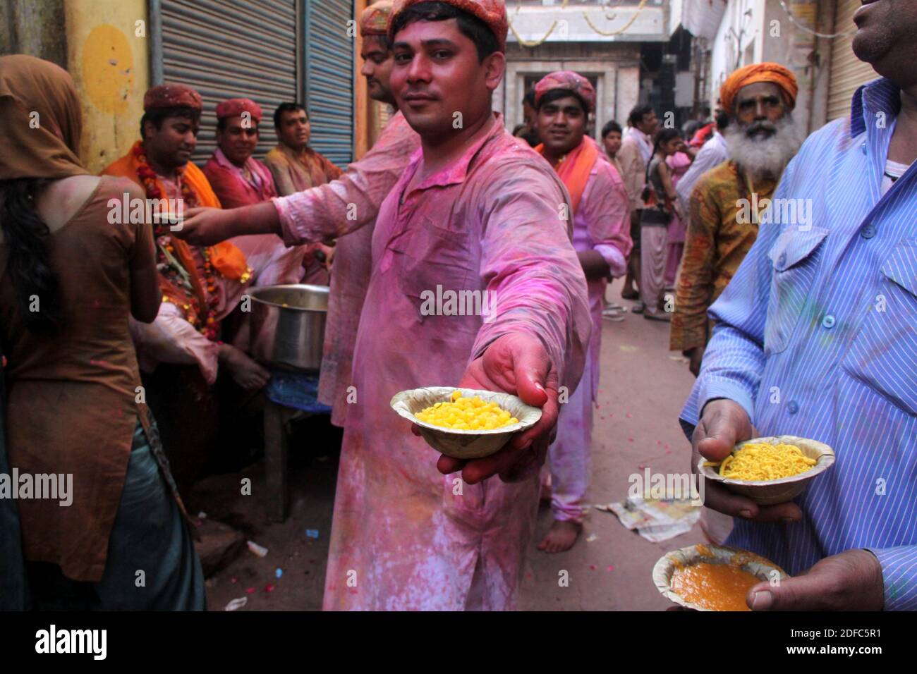 India, Uttar Pradesh, Vrindavan, man offering food (prasads) during ...