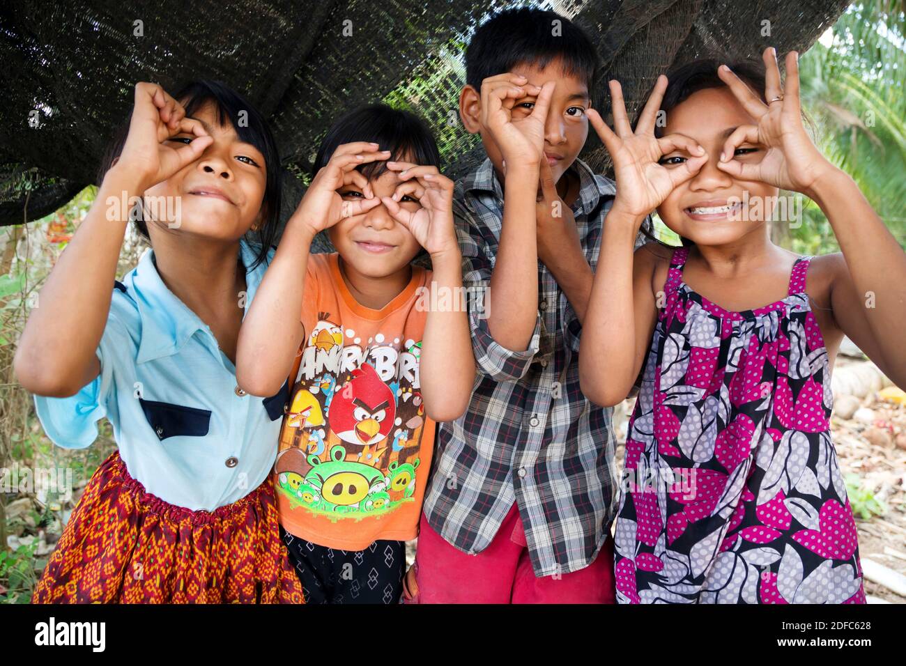 Cambodia, Phnom Penh, group of children smiling and imitating a camera with their hands Stock ...