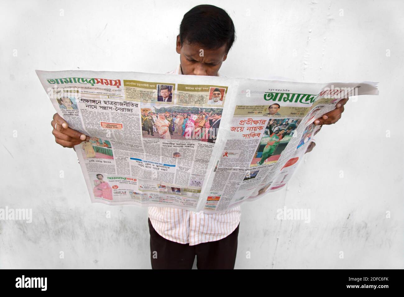 Bangladesh, Dhaka, man reads newspaper in Bengali language Stock Photo - Alamy