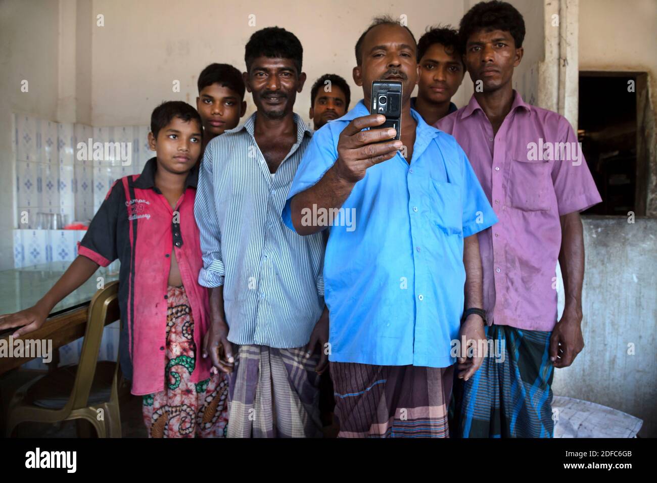 Bangladesh, a group of men take a photo with a mobile phone in ...