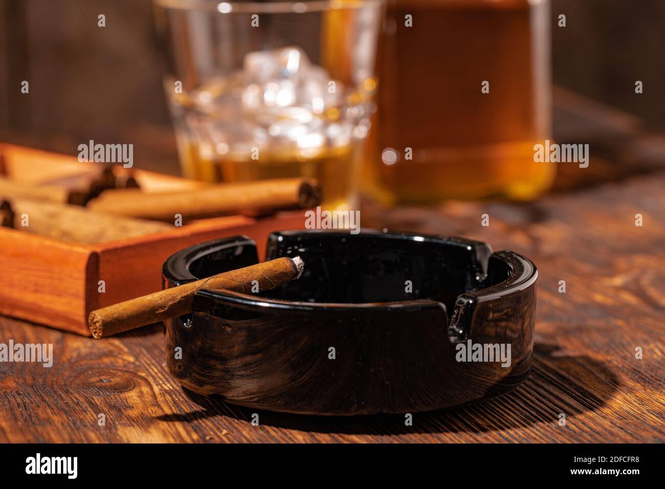 Glass of whisky and lighted cigar in an ash tray Stock Photo - Alamy