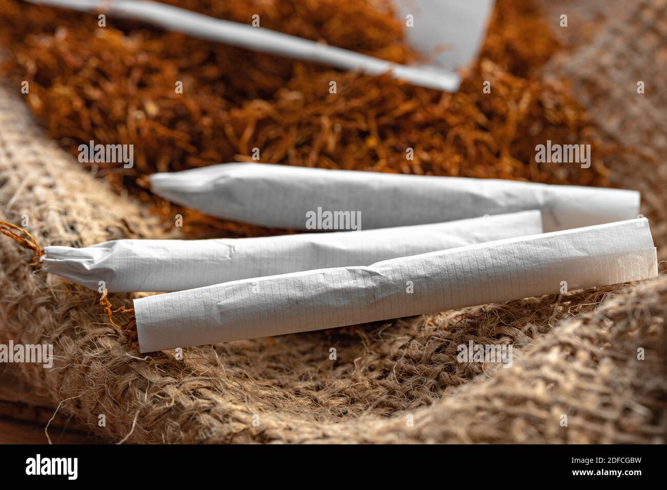 Cigarette paper and pile of tobacco on wooden table Stock Photo - Alamy