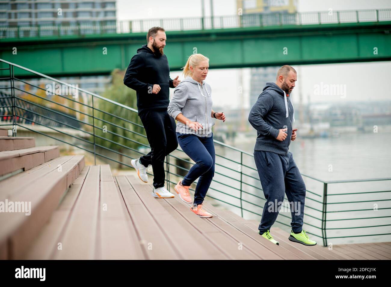 Three young friends running on the steps Stock Photo - Alamy