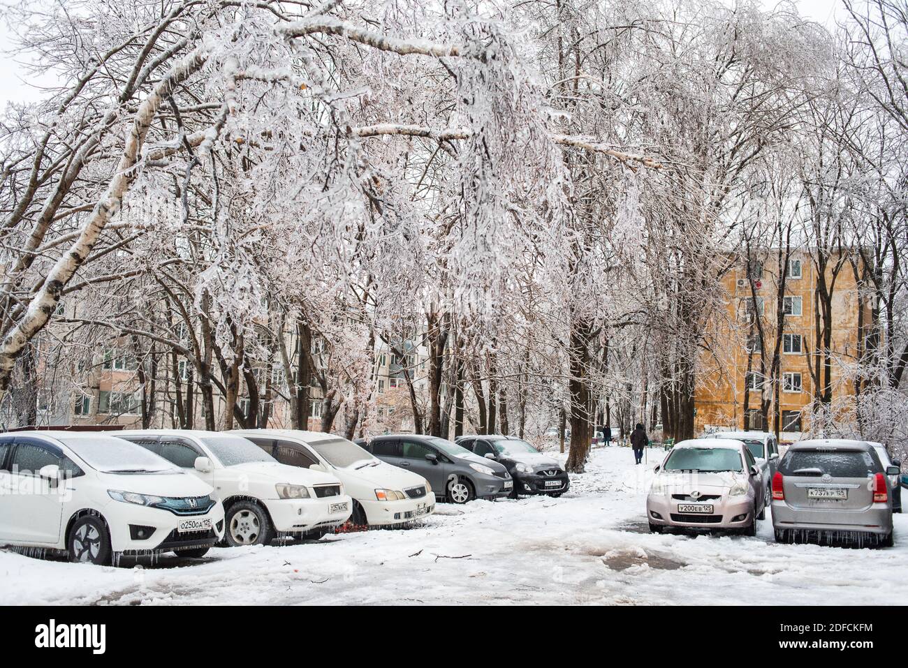 View of the city and road in bad snowy weather. Cars covered with ice ...