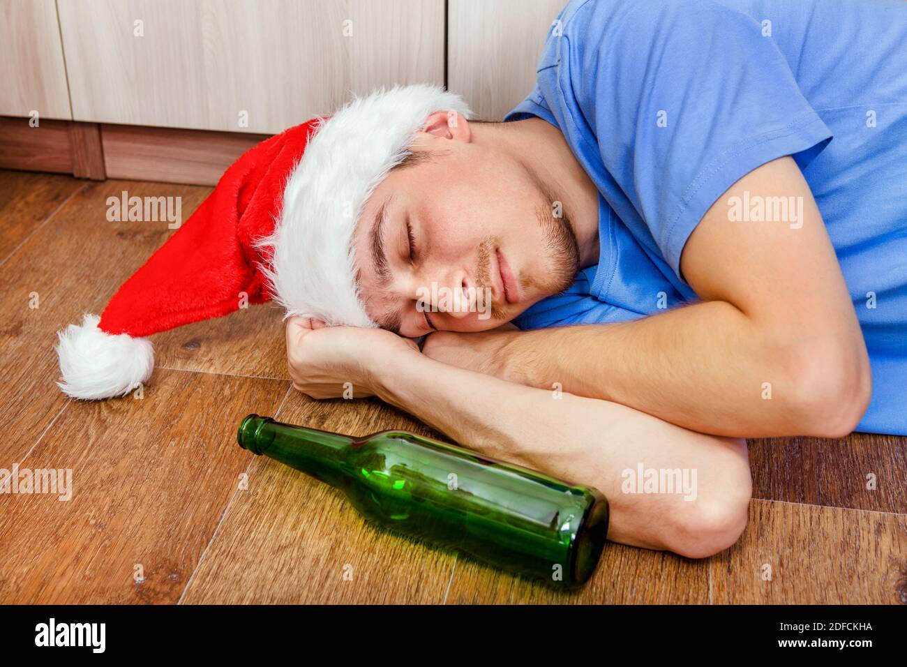 A Man in Santa Hat sleeping on the Floor with a Beer Stock Photo - Alamy