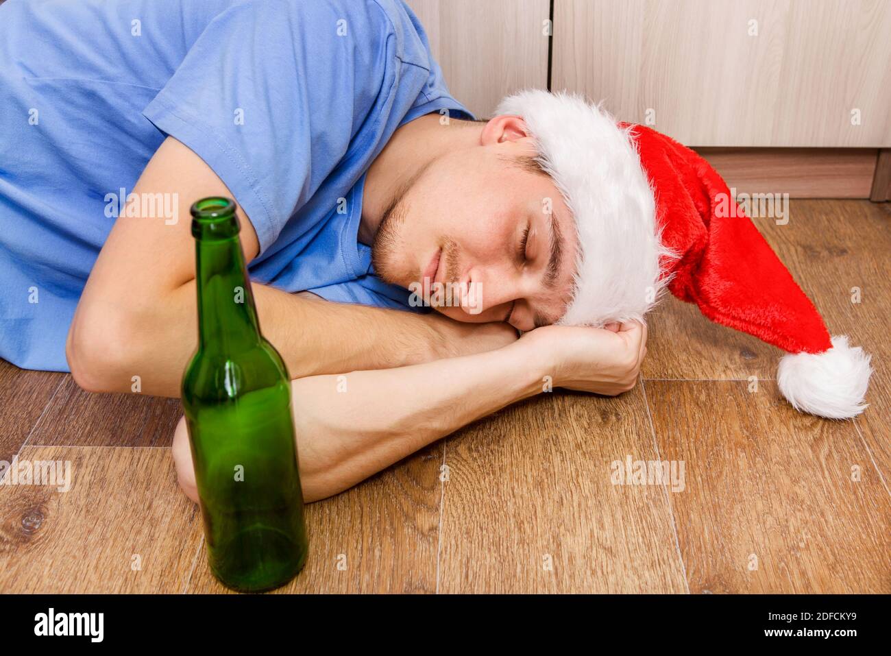 Young Man in Santa Hat sleeping on the Floor with a Beer Stock Photo ...
