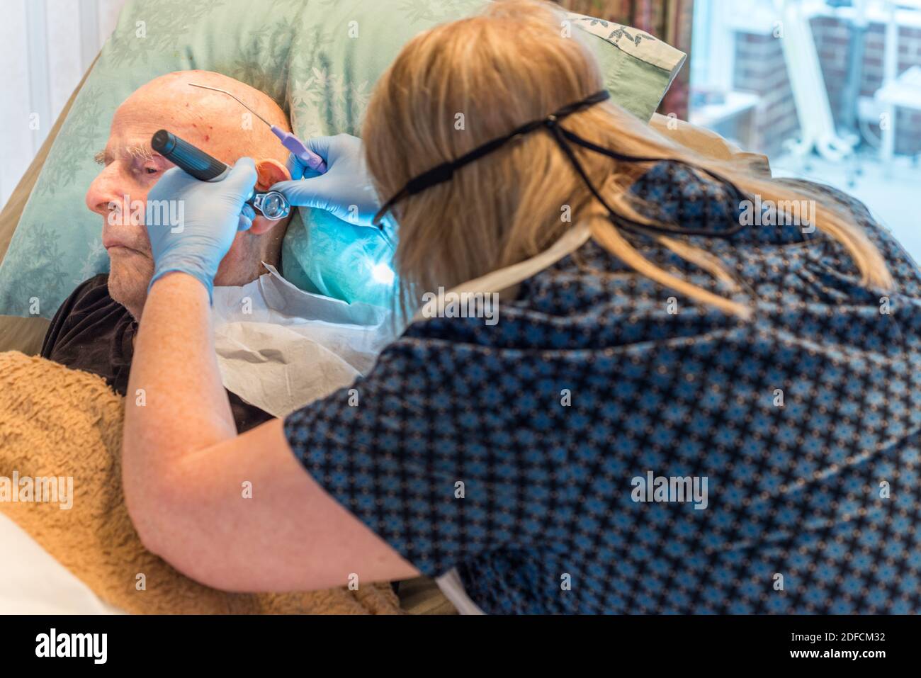 Bedbound elderly man undergoing unpleasant but necessary treatment for ...