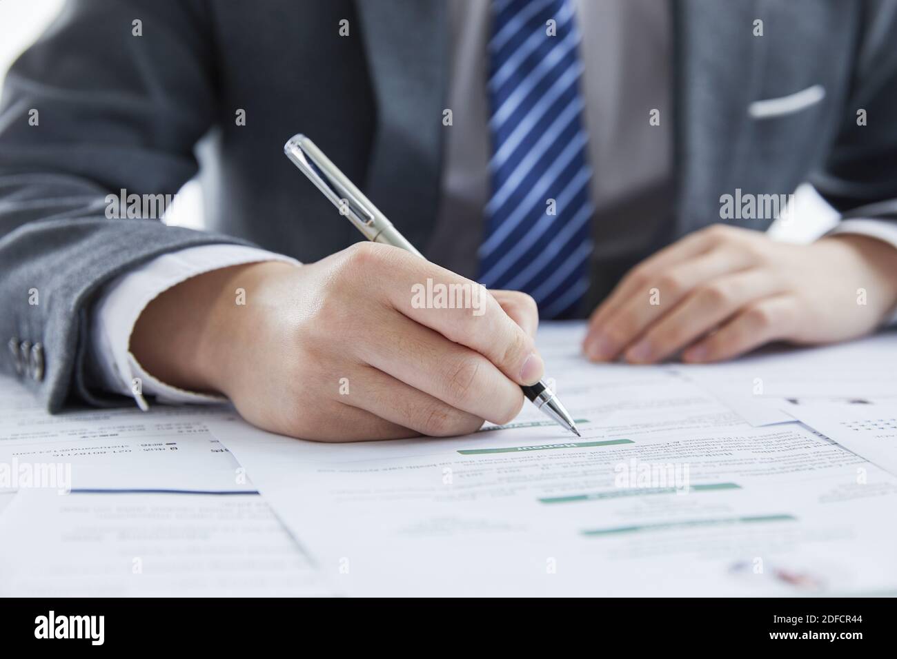 The businessman in elegant suit at a business meeting signing contracts ...