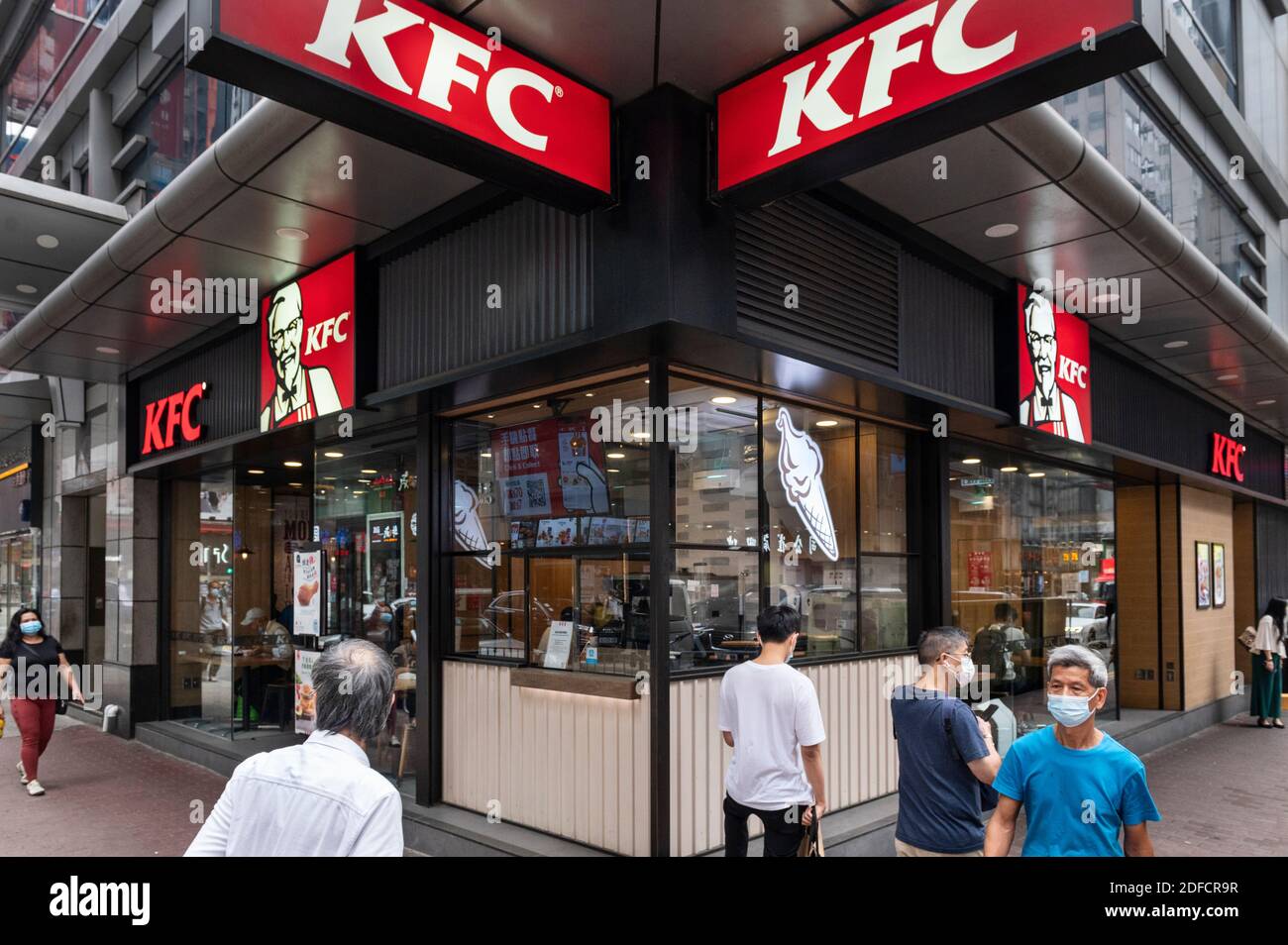 Pedestrians walk past an American fast food chicken restaurant chain ...