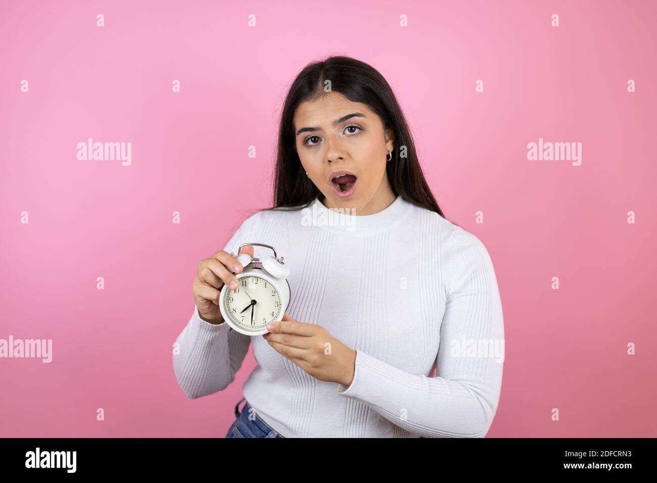 Young beautiful woman over isolated pink background screaming and ...
