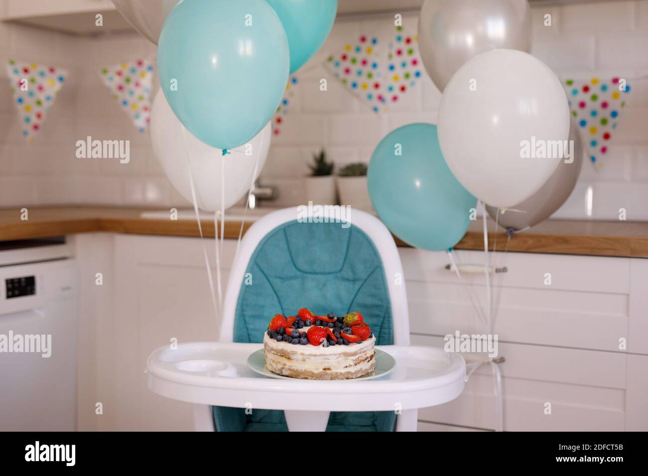 Children's high chair is decorated with blue and white balls to ...
