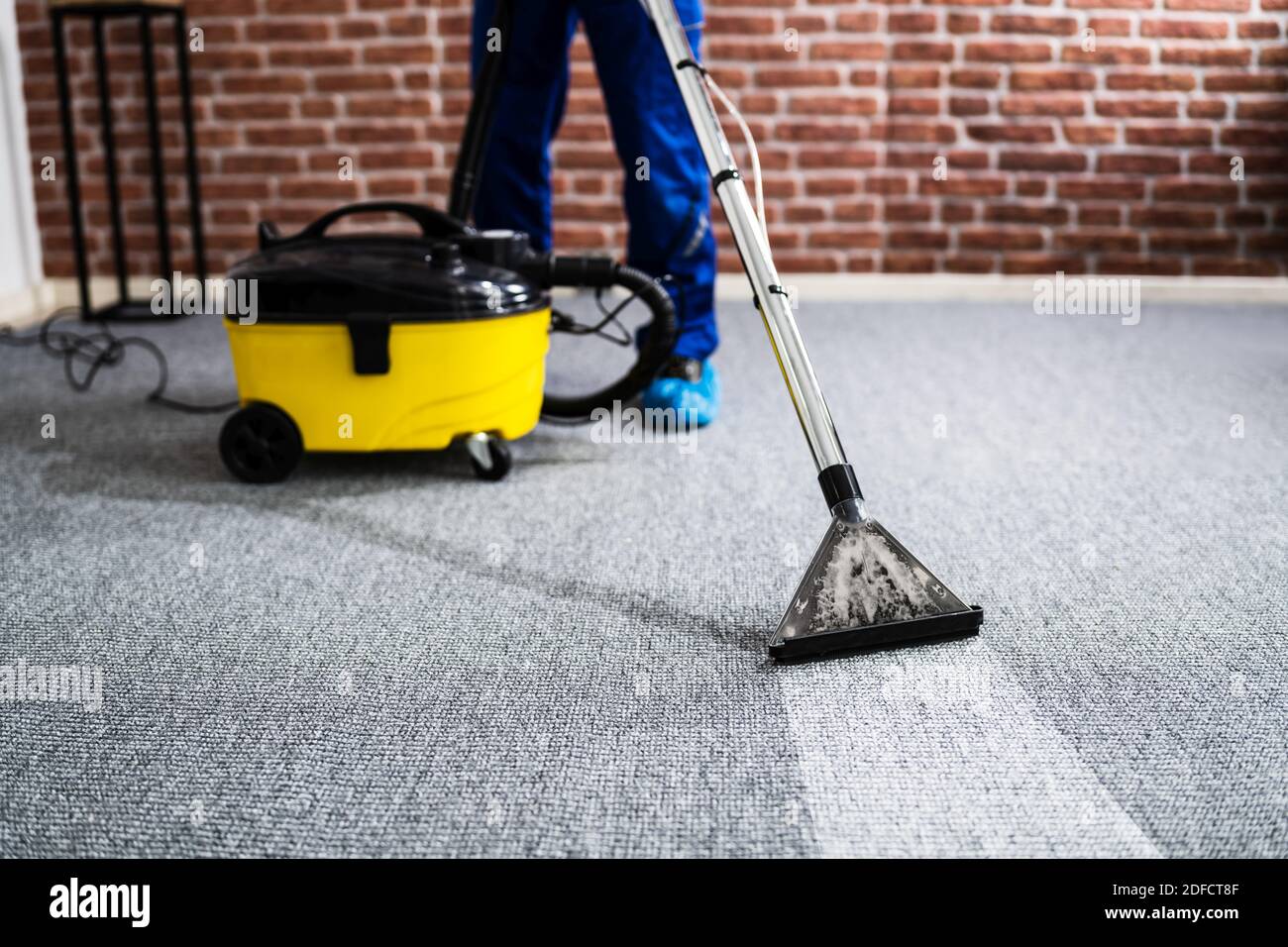 Janitor Cleaning Carpet With Vacuum Cleaner At Home Stock Photo - Alamy