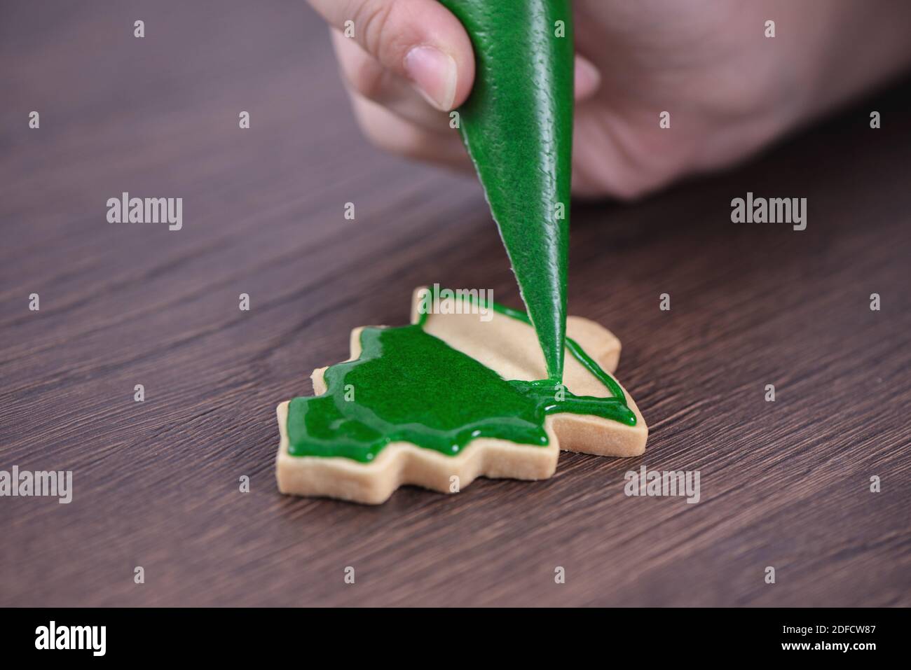 Close up of drawing gingerbread Christmas tree sugar cookie on wooden ...