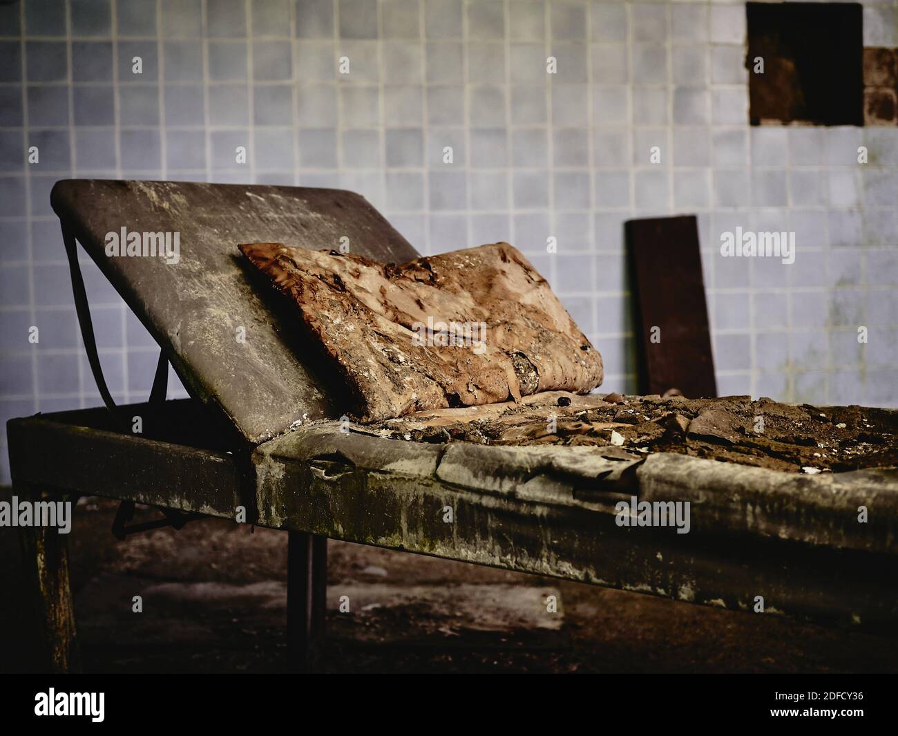 A closeup of an old decaying rusty medical bed in an abandoned room ...