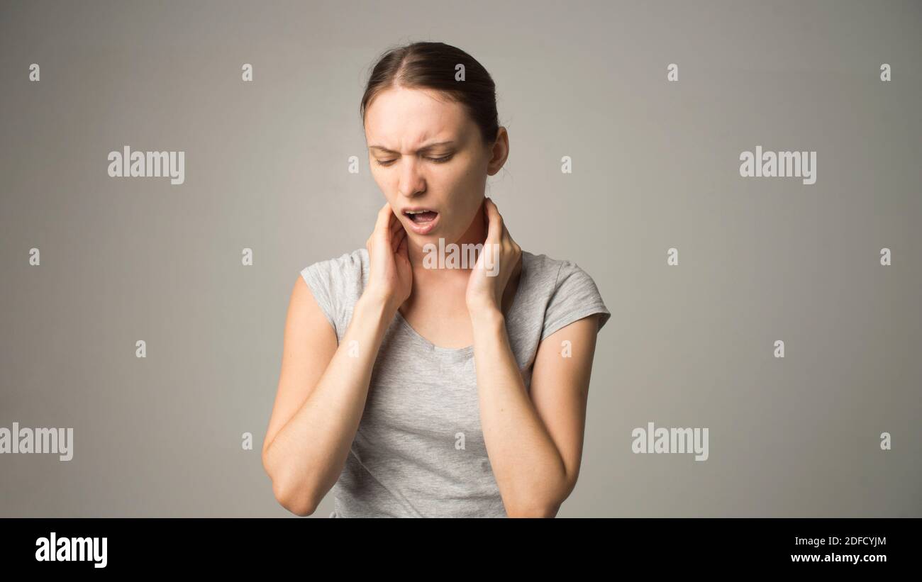 Tired woman feeling pain, massaging tense muscles Stock Photo - Alamy