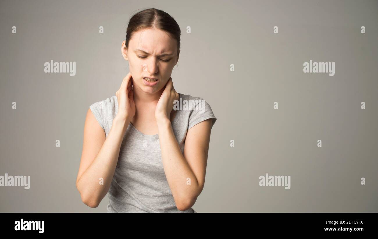 Tired woman feeling pain, massaging tense muscles Stock Photo - Alamy