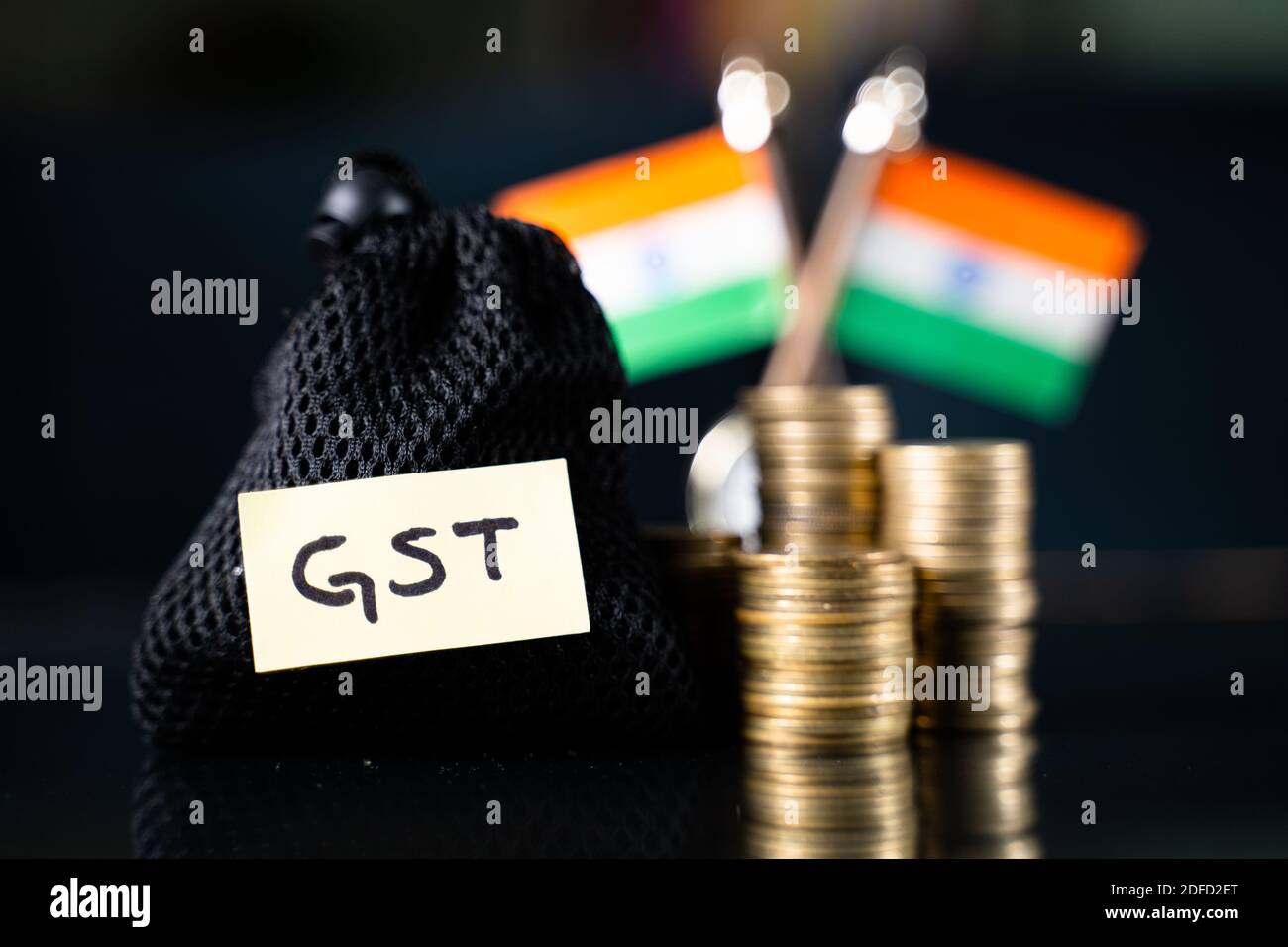 Bag with GST sticker in front of the stack of Coins and Indian flag as ...