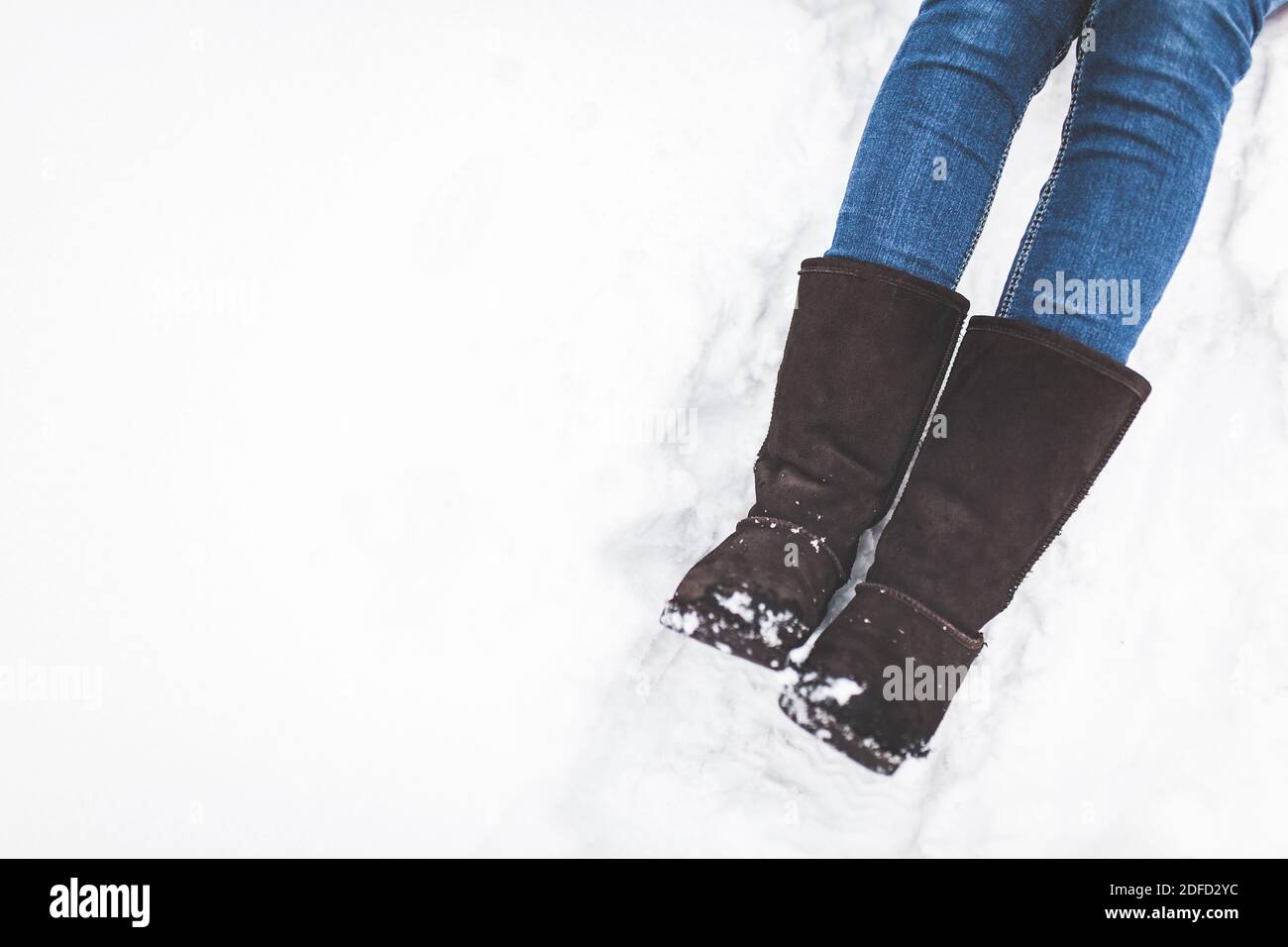 Winter image of legs in boots on snow, the snow, the girl sits, to ...