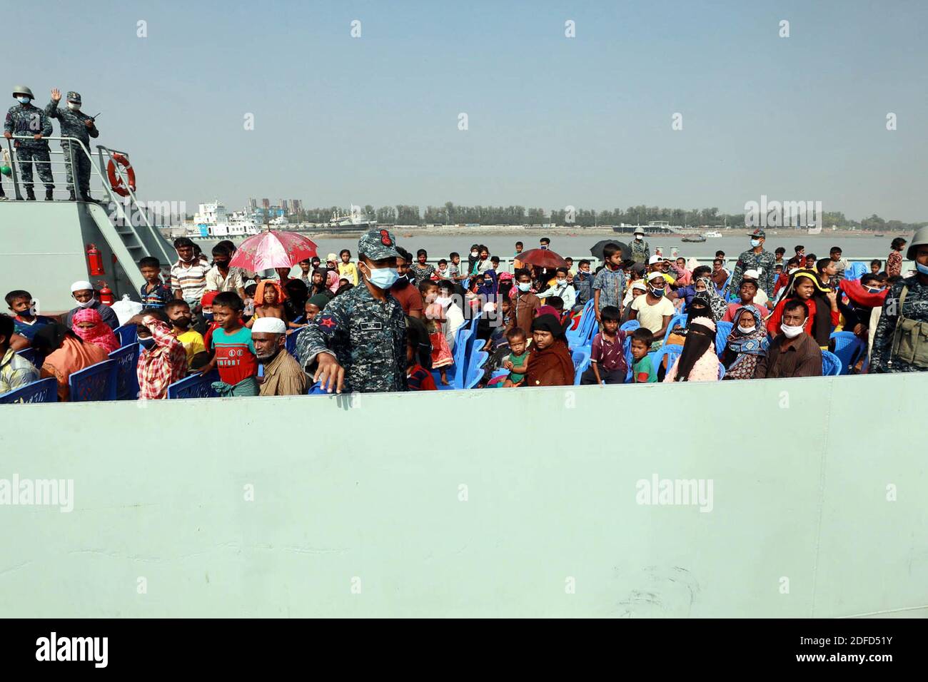 Rohingya refugees board a Bangladesh Navy ship to be transported to the ...