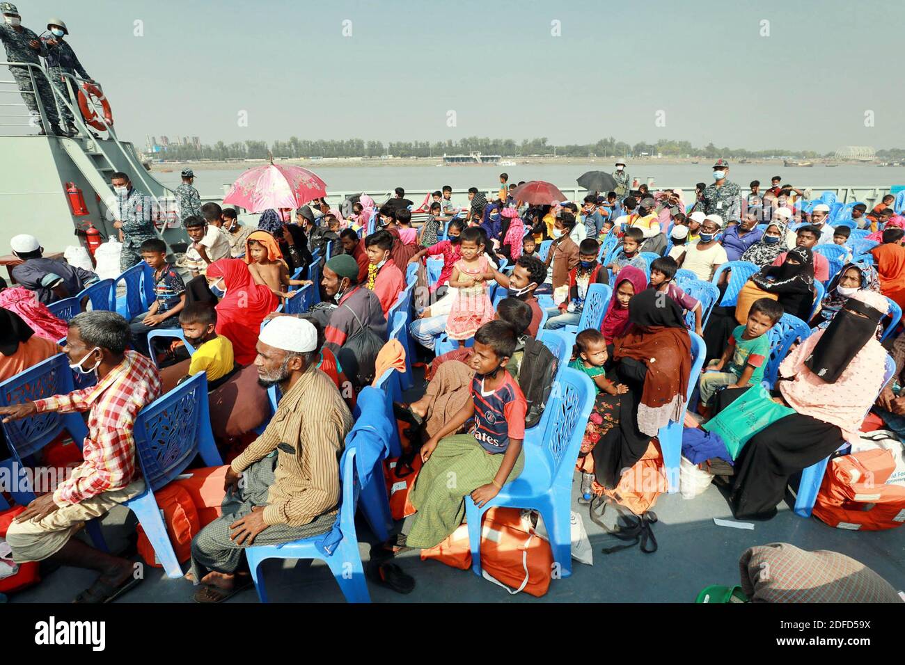 Rohingya refugees board a Bangladesh Navy ship to be transported to the ...