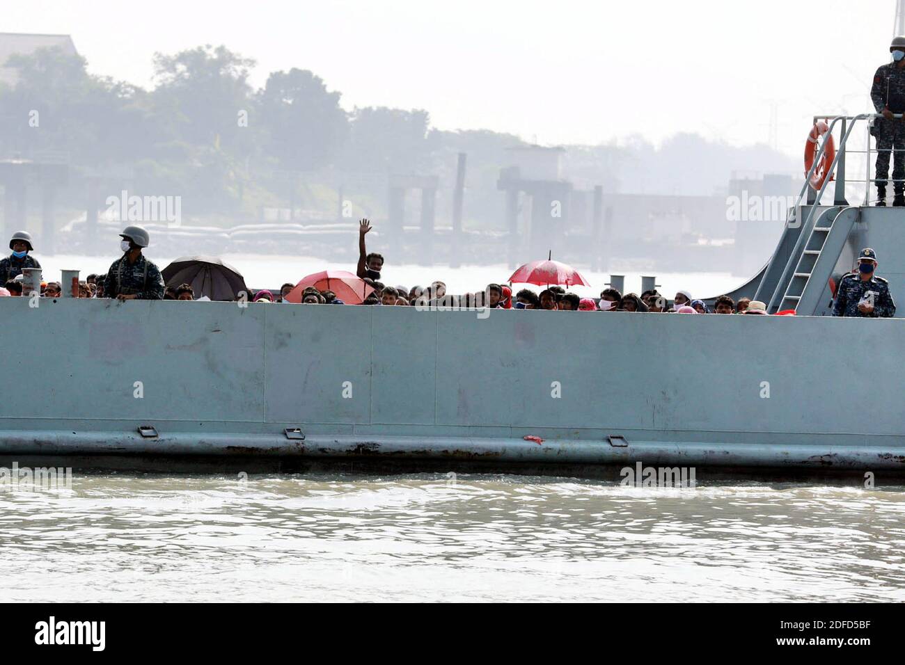 Rohingya refugees board a Bangladesh Navy ship to be transported to the ...