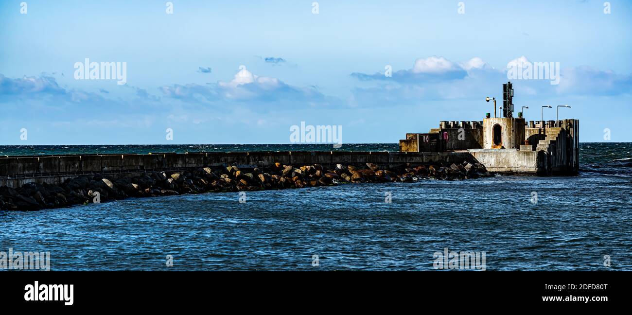 Long pier made from concrete and rocks, protecting a large port from ...