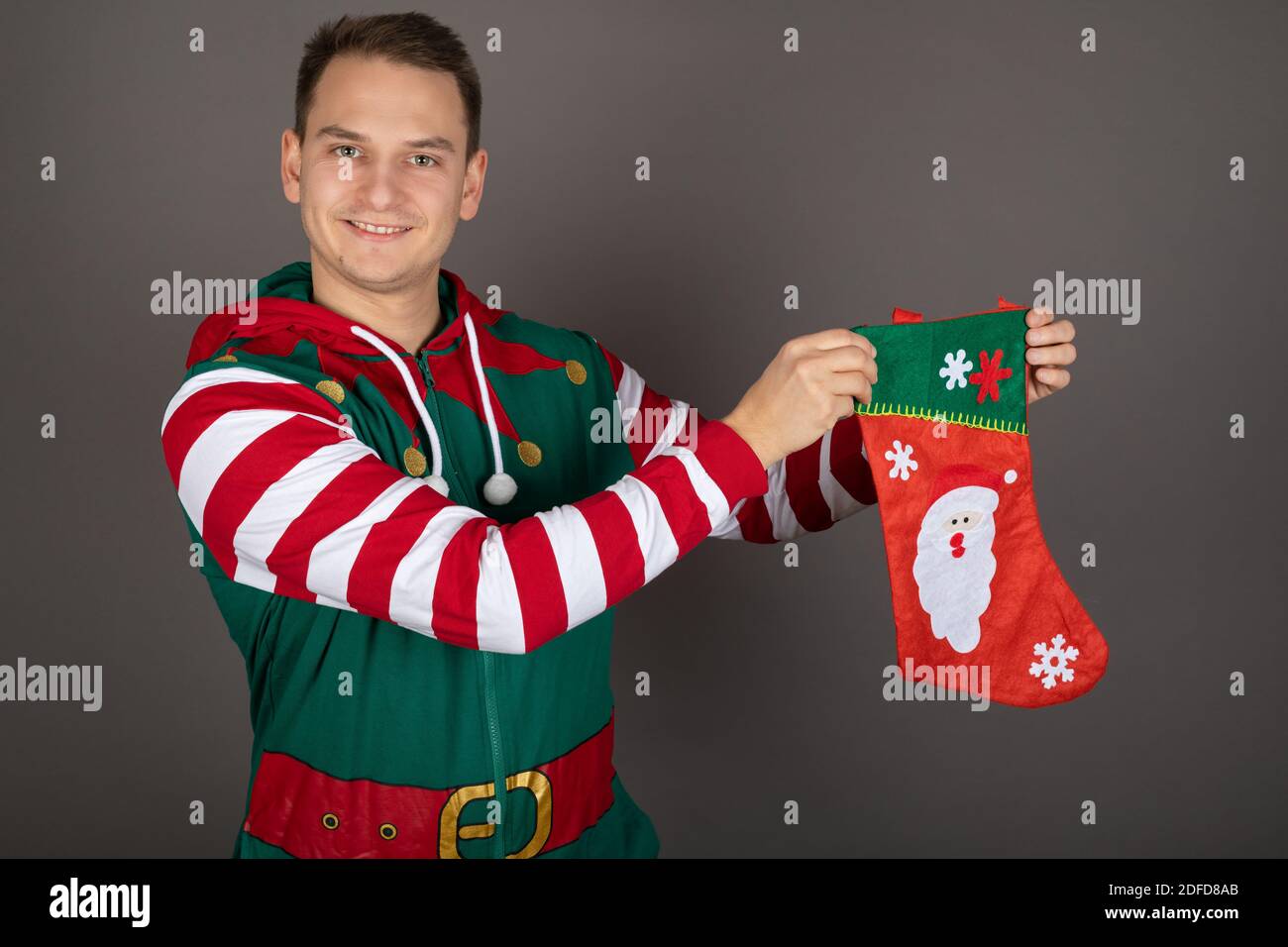 Portrait of handsome man wearing Grinch costume is smiling to the ...