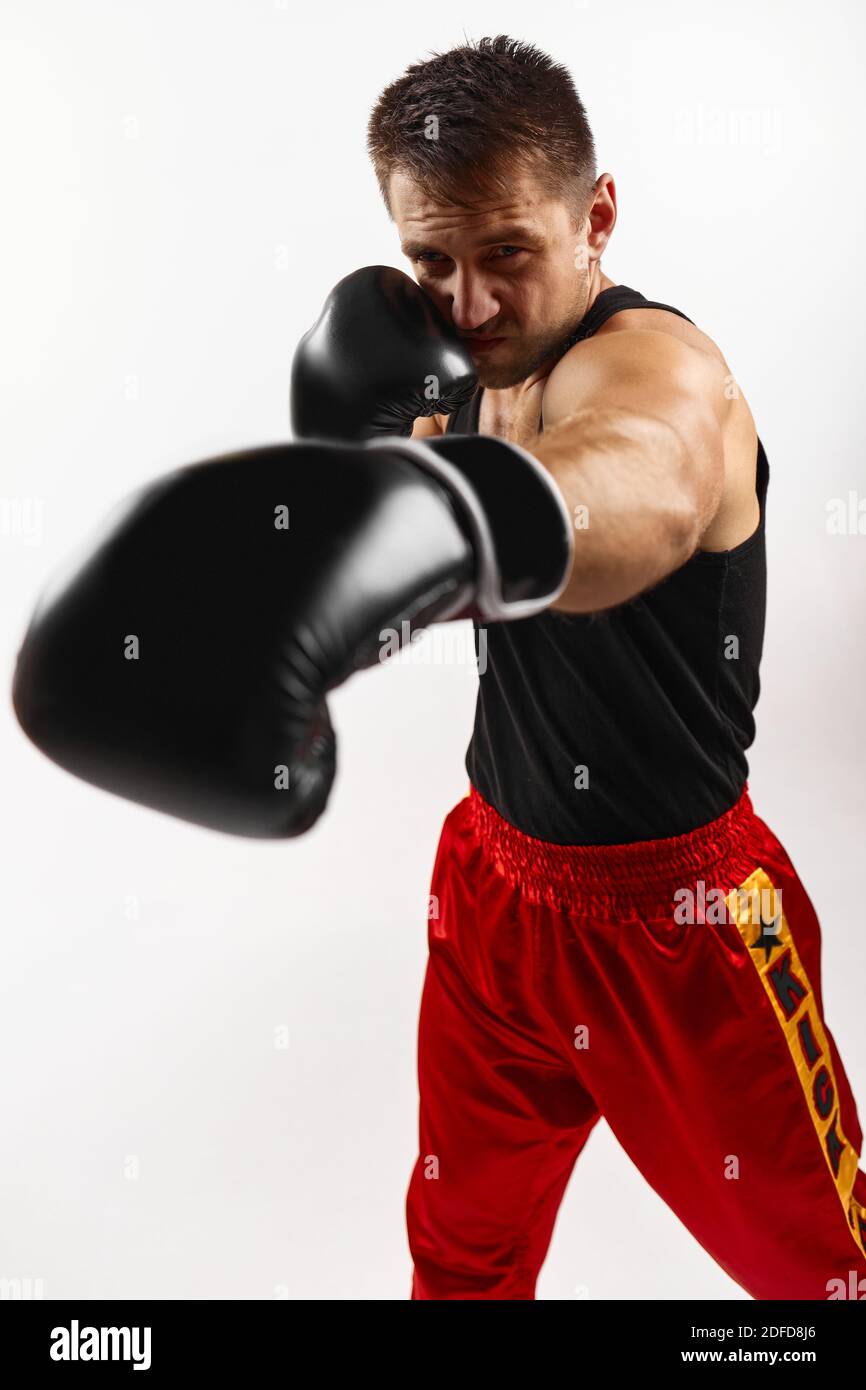 sporty man in black boxing gloves punching isolated on white background ...