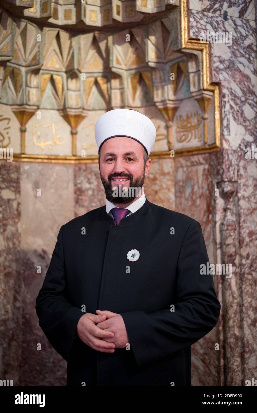 Emam in mosque with verses from Kuran on the wall Stock Photo - Alamy