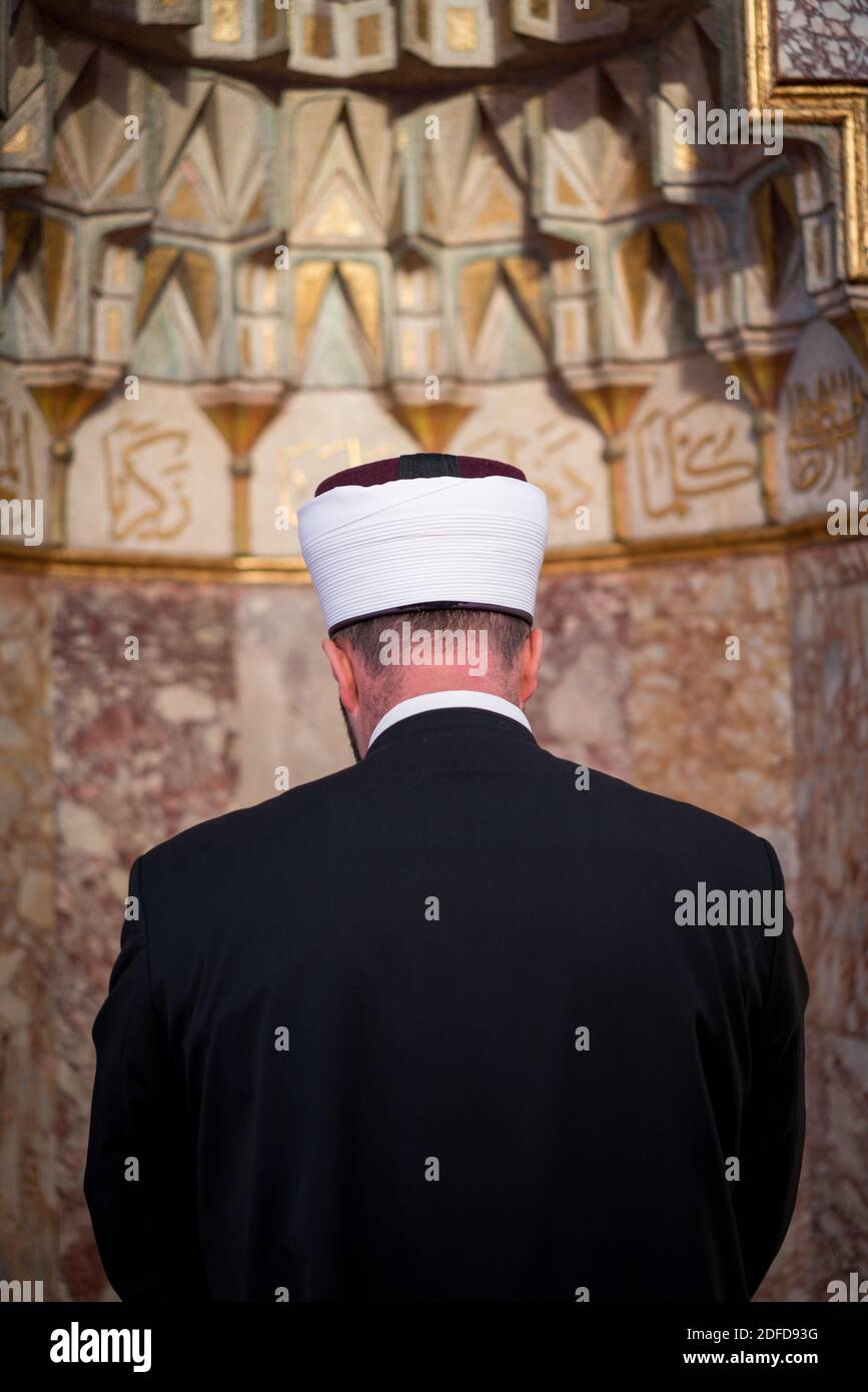 Emam in mosque with verses from Kuran on the wall Stock Photo - Alamy