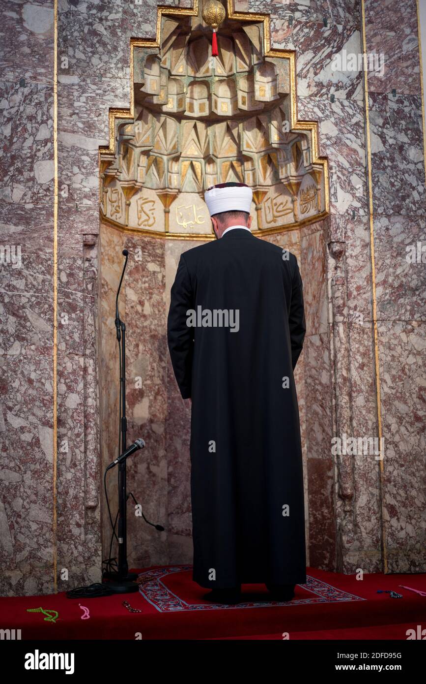 Emam in mosque with verses from Kuran on the wall Stock Photo - Alamy