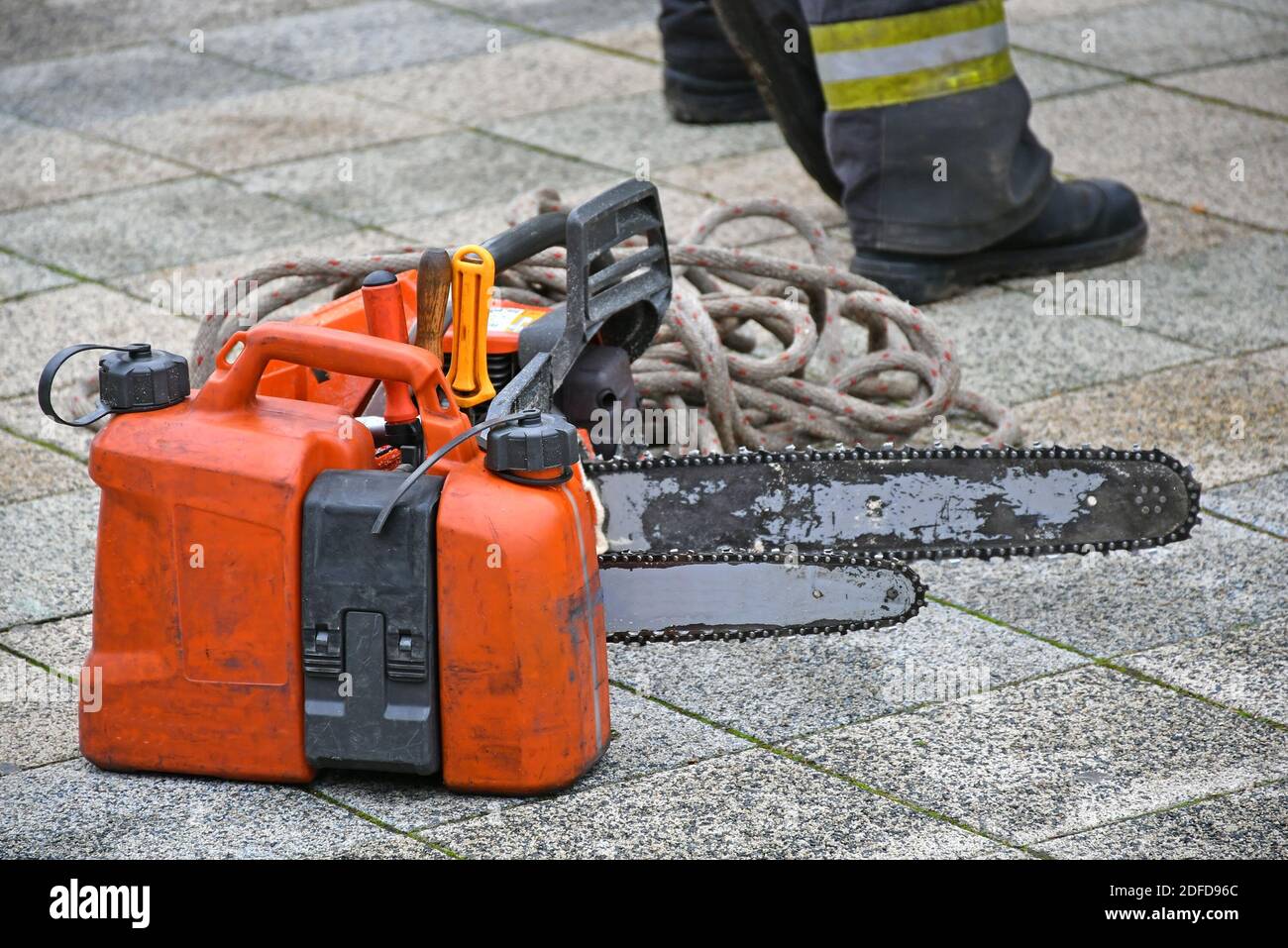 Chainsaw rope and oil tank on the paving stone Stock Photo - Alamy