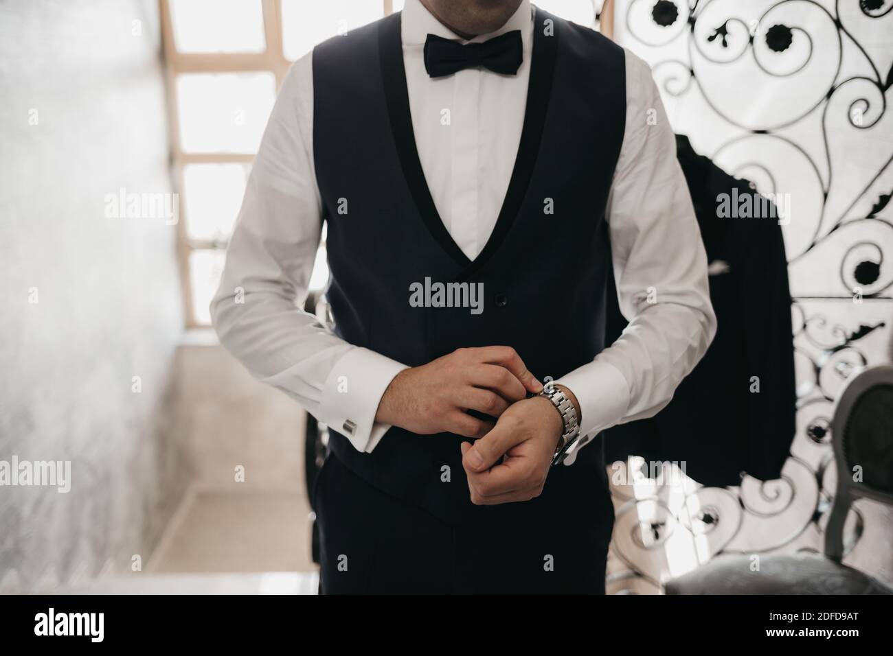 A groom buttoning his coat for the wedding day Stock Photo - Alamy