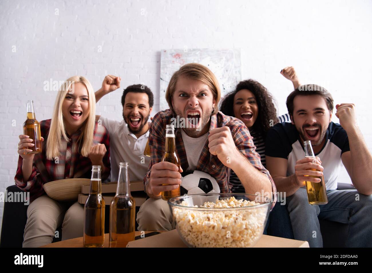excited man shouting and showing win gesture while watching football ...